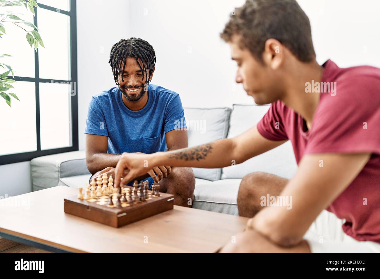Two men friends playing chess sitting on sofa at home Stock Photo - Alamy