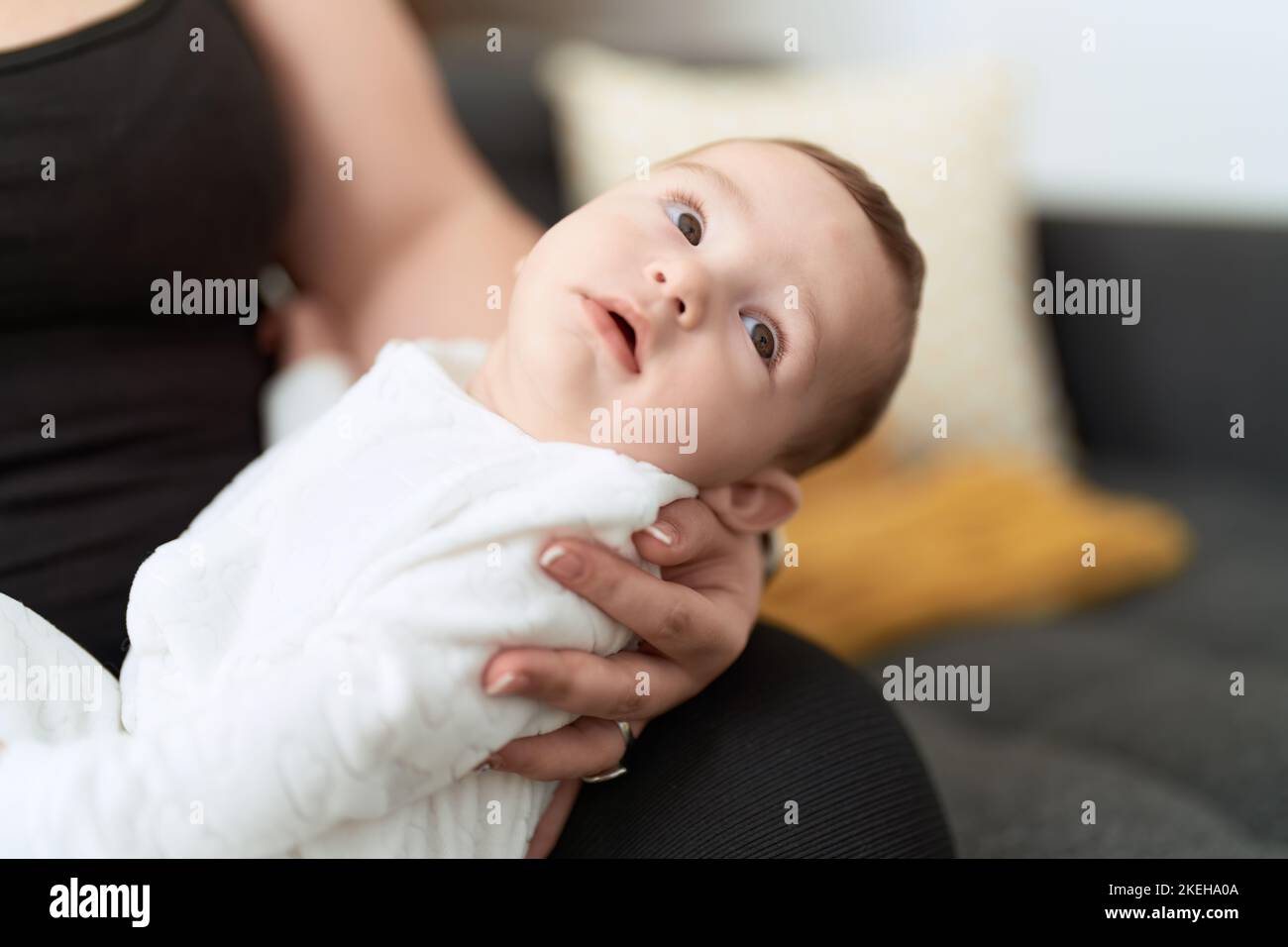 Adorable toddler on mother arms sitting on sofa at home Stock Photo - Alamy
