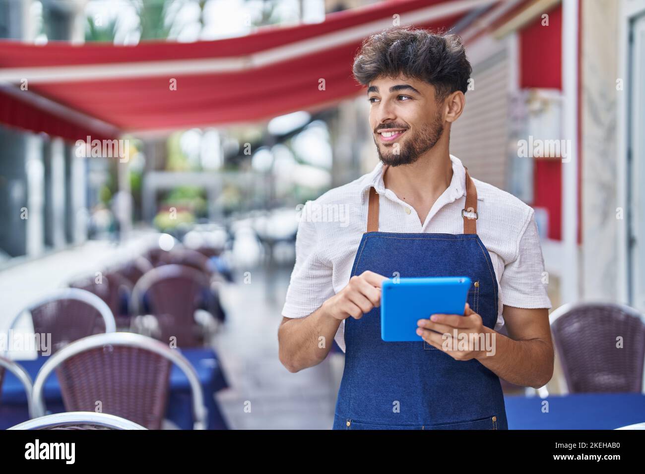 Young arab man waiter using touchpad working at restaurant Stock Photo ...
