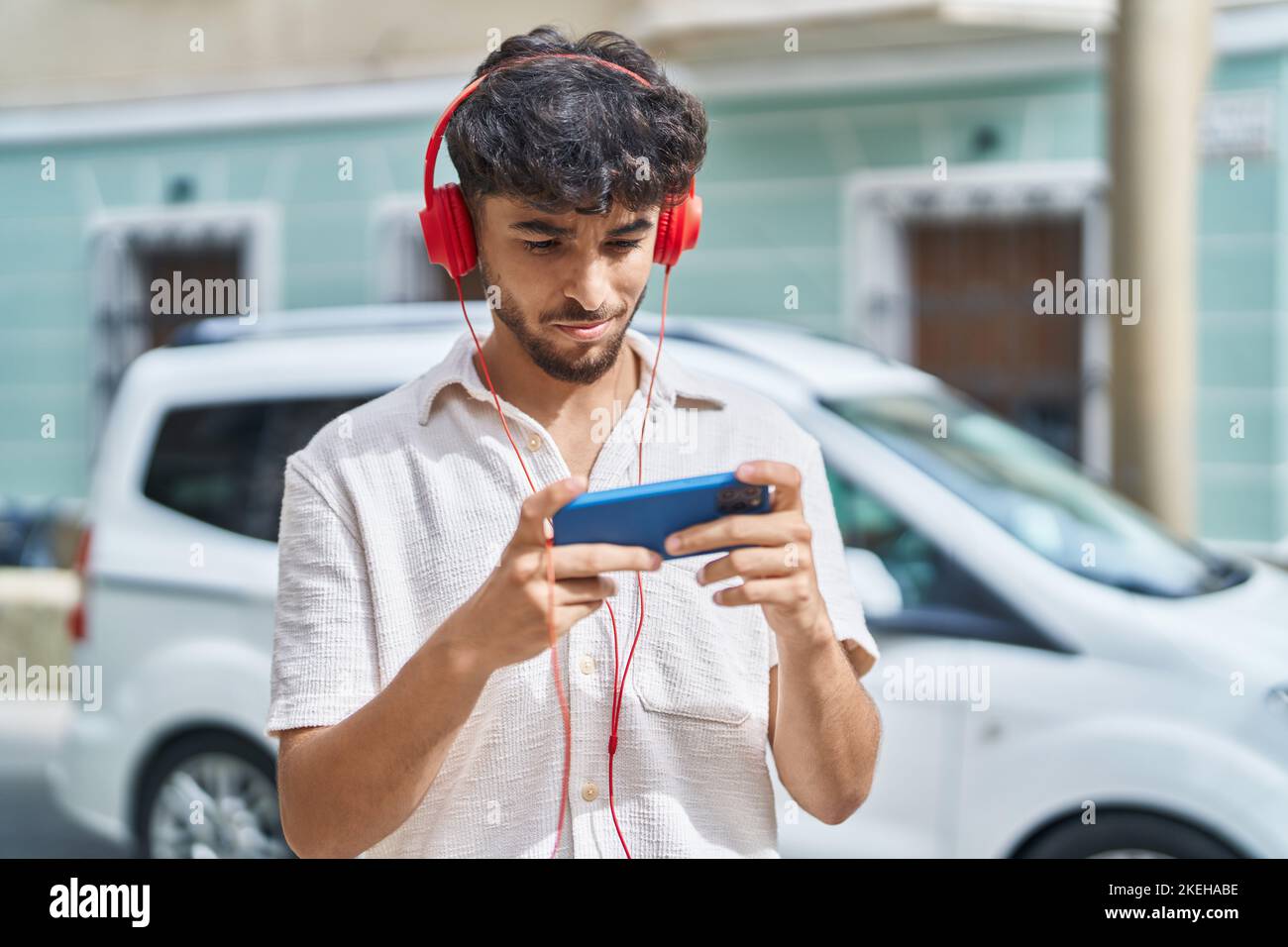 Young arab man playing video game at street Stock Photo - Alamy