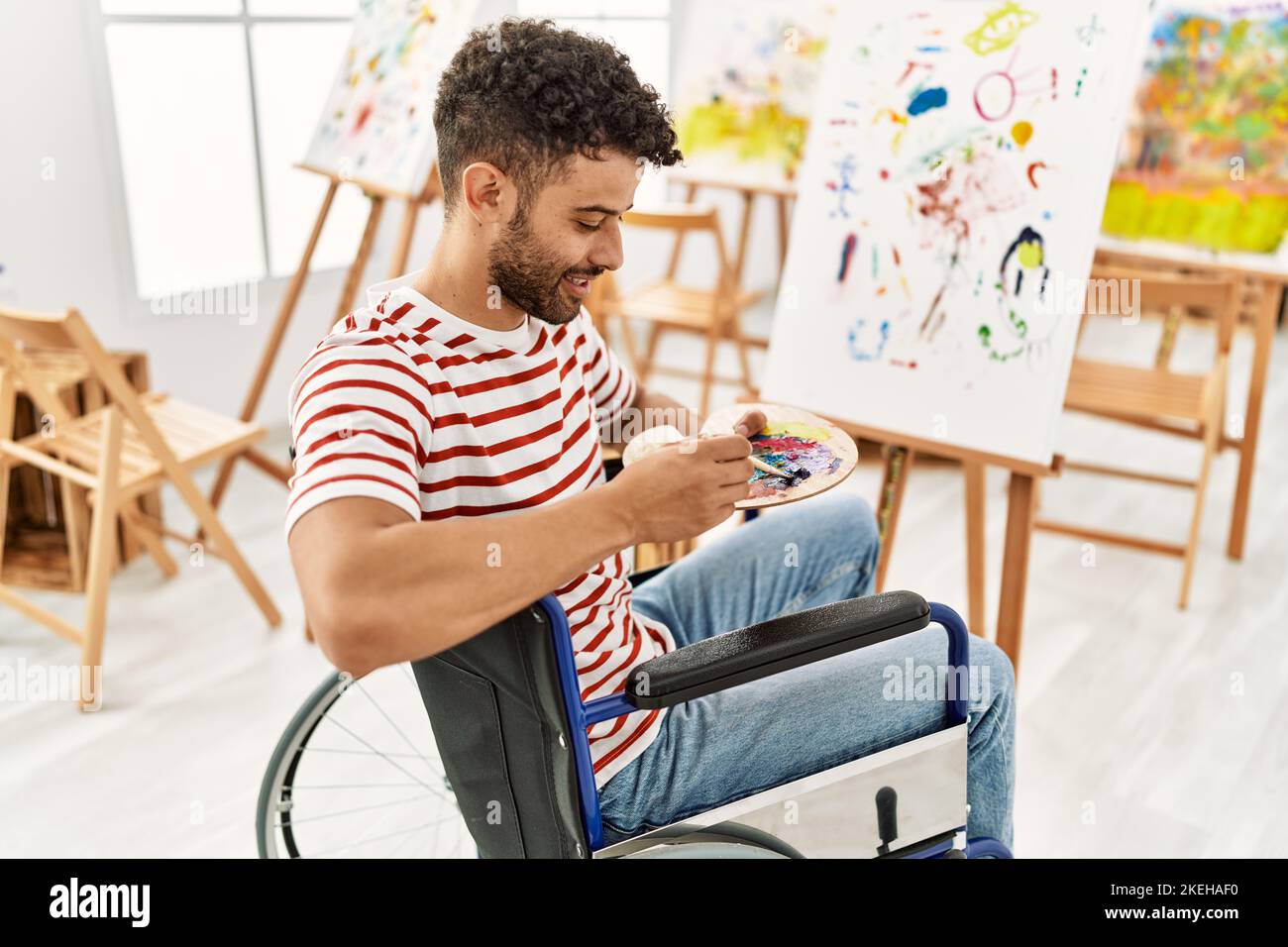 Young arab disabled artist man drawing sitting on wheelchair at art ...