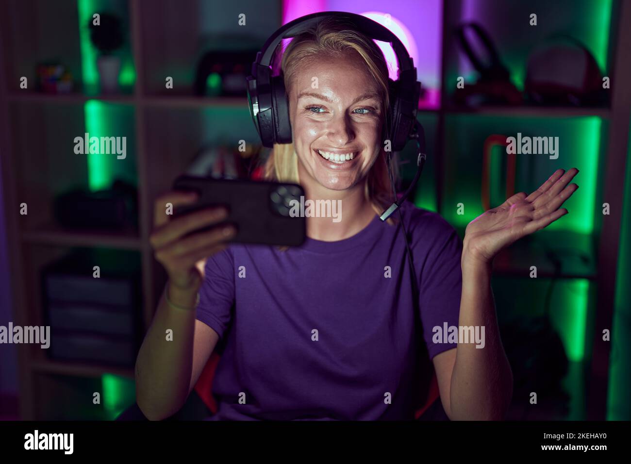 Young gamer woman playing video games with smartphone celebrating ...