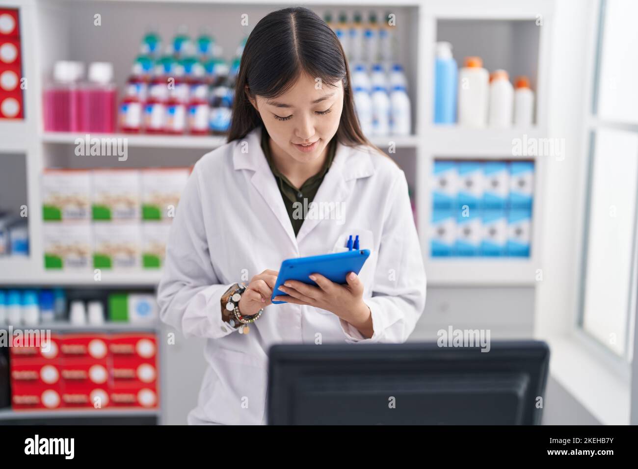 Chinese woman pharmacist using touchpad working at pharmacy Stock Photo ...