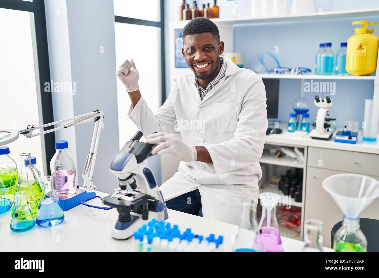 African american man working at scientist laboratory screaming proud ...