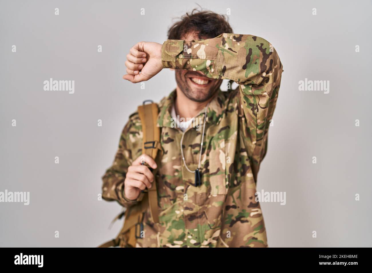 Hispanic young man wearing camouflage army uniform smiling cheerful ...