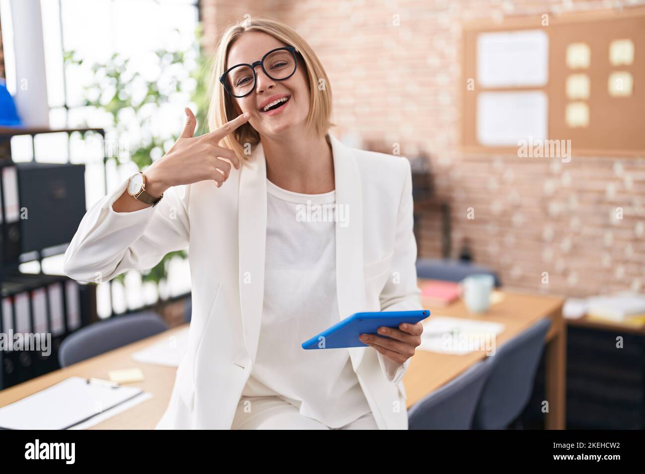 Young caucasian woman working at the office wearing glasses smiling ...