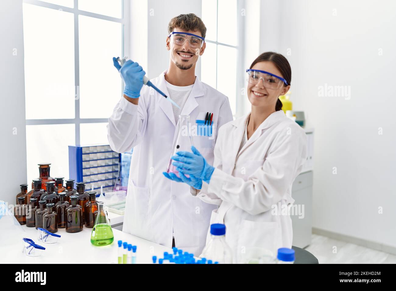 Man and woman partners wearing scientist uniform holding test tube and ...