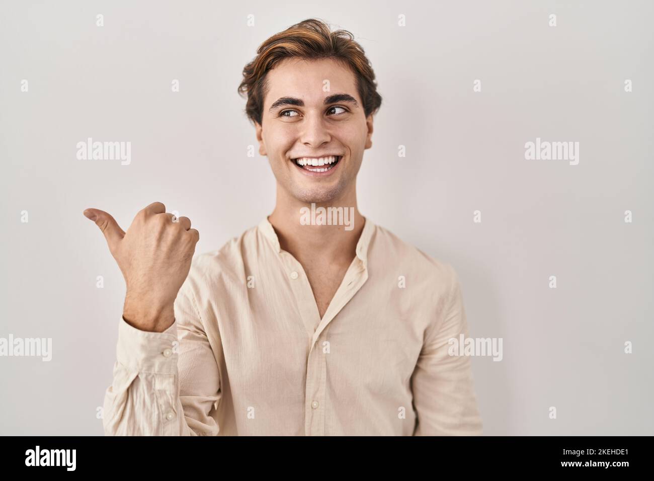 Young man standing over isolated background smiling with happy face ...