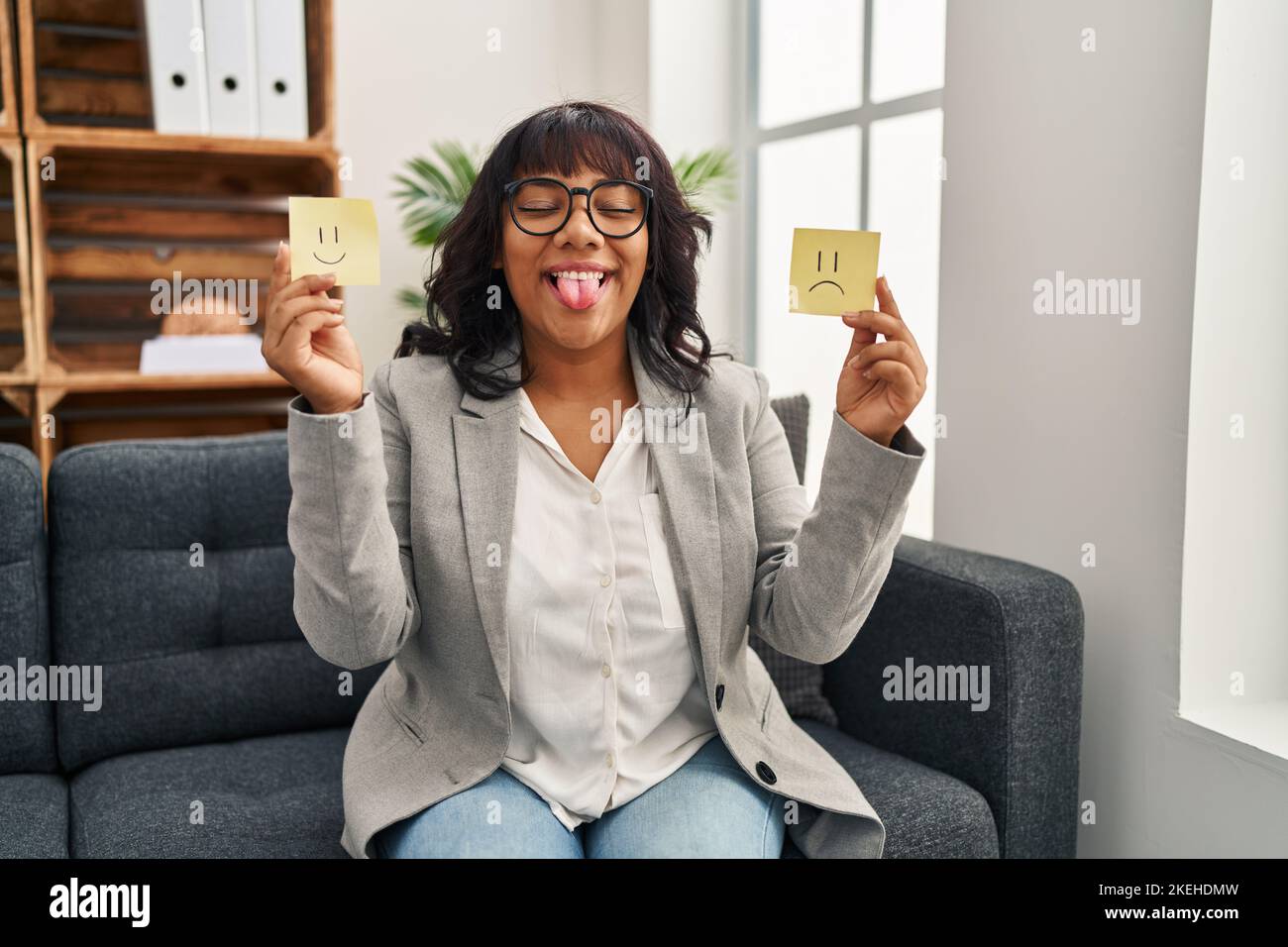 Hispanic woman working on depression holding sad to happy emotion paper ...