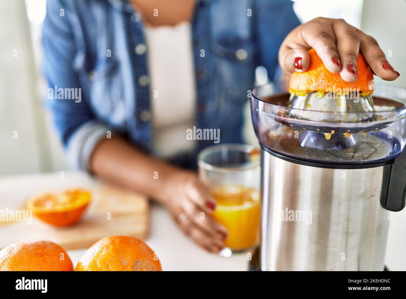 Hispanic brunette woman preparing orange juice at the kitchen Stock ...