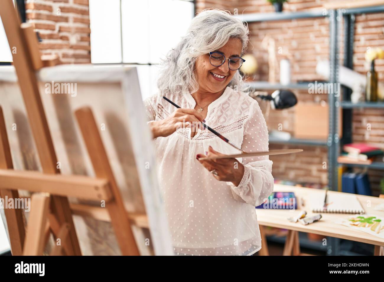 Middle age woman artist smiling confident drawing at art studio Stock ...
