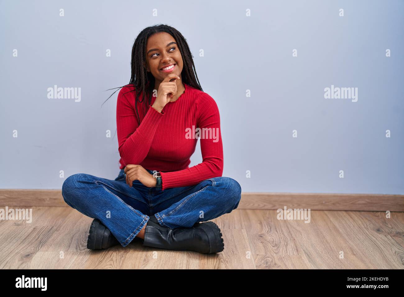 Young african american with braids sitting on the floor at home with ...