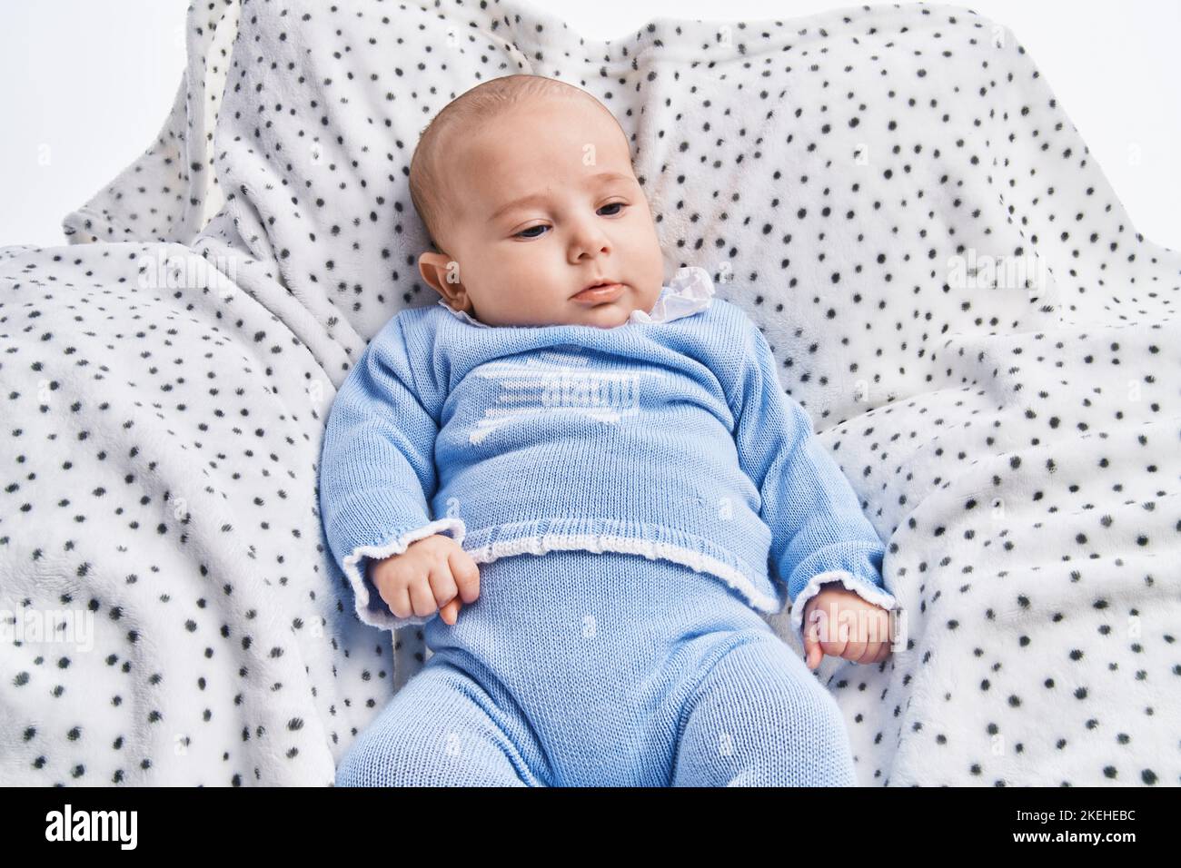 Adorable baby relaxed lying on sofa over white isolated background Stock Photo - Alamy