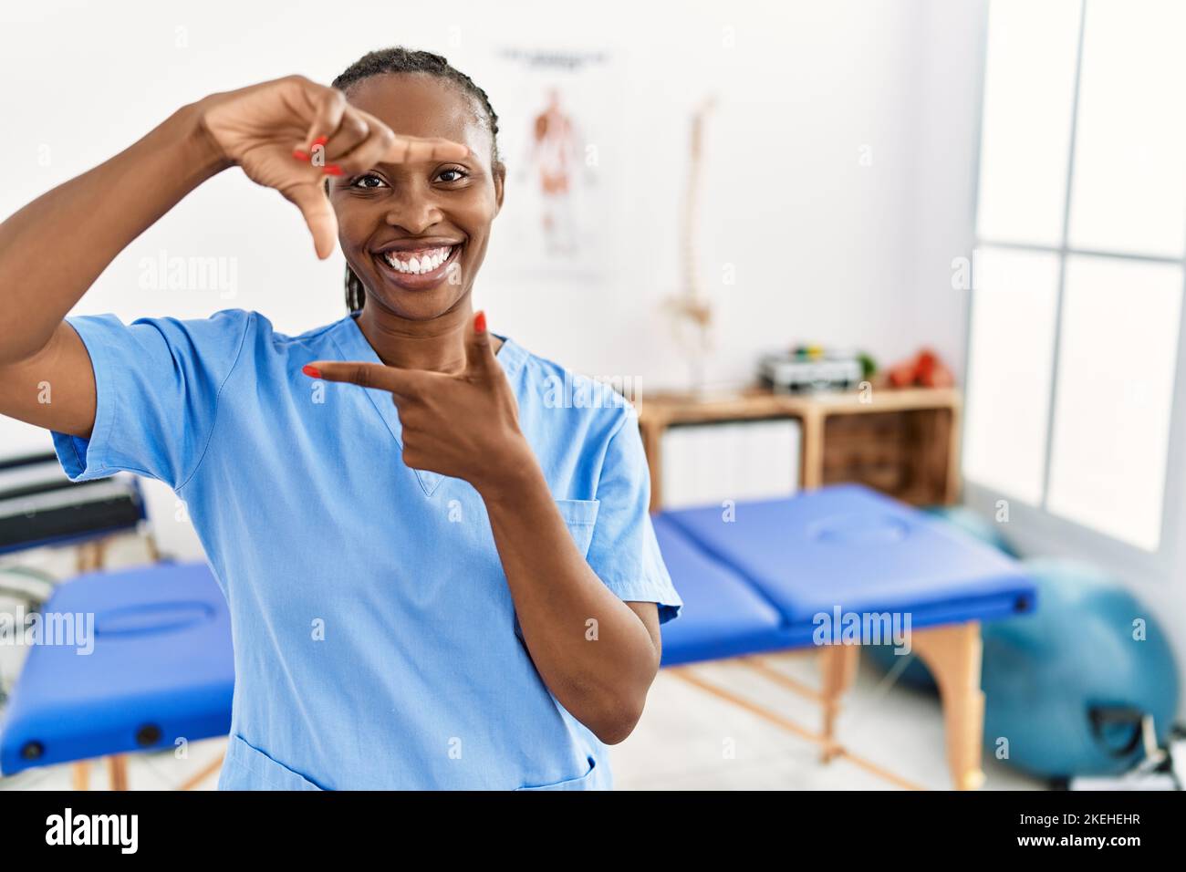 Black woman with braids working at pain recovery clinic smiling making ...