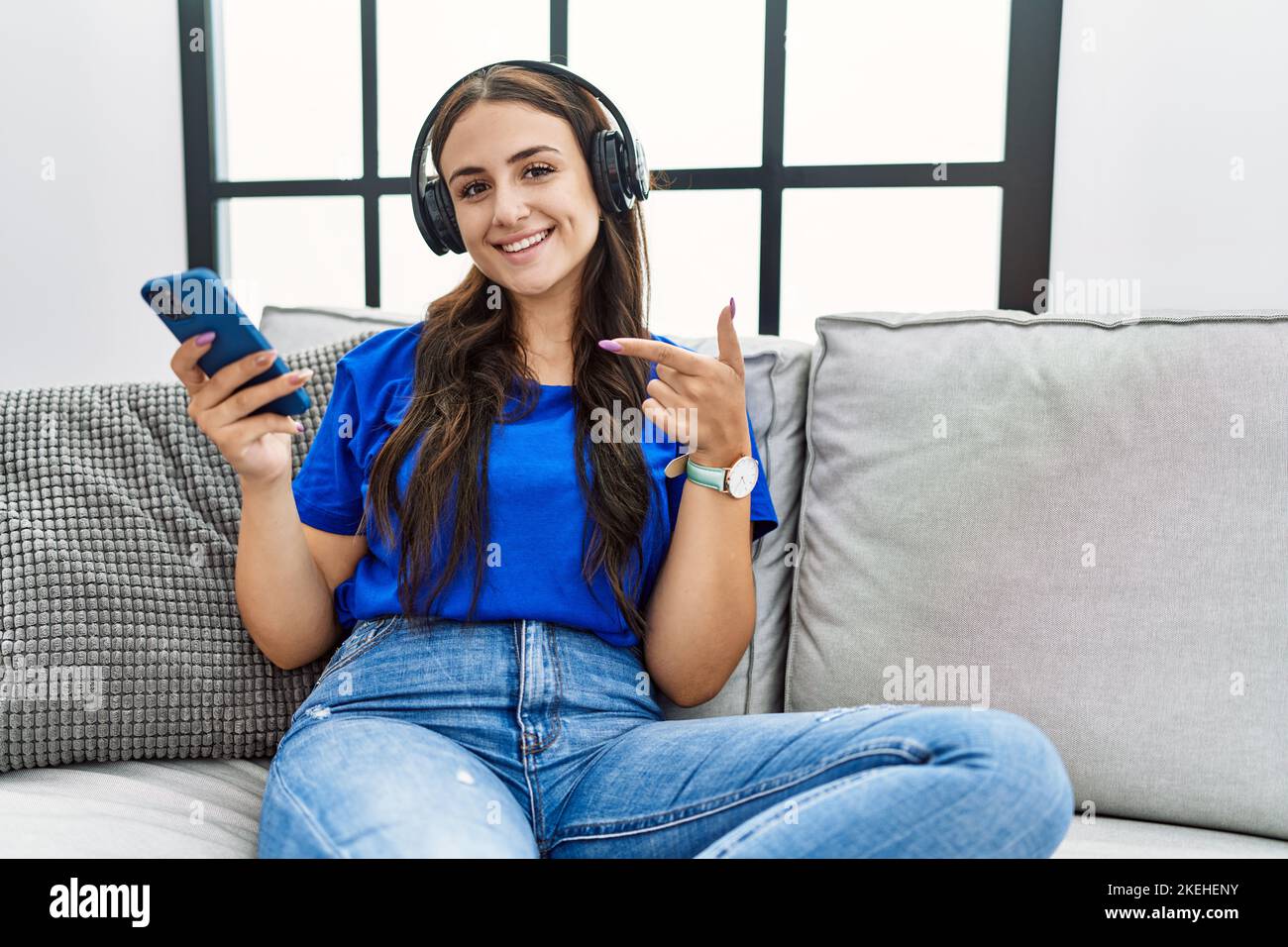 Young brunette woman listening to music from smartphone using ...