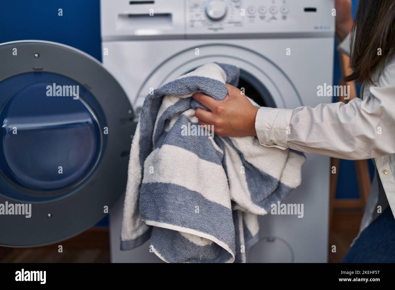 Young hispanic woman washing clothes at laundry room Stock Photo - Alamy