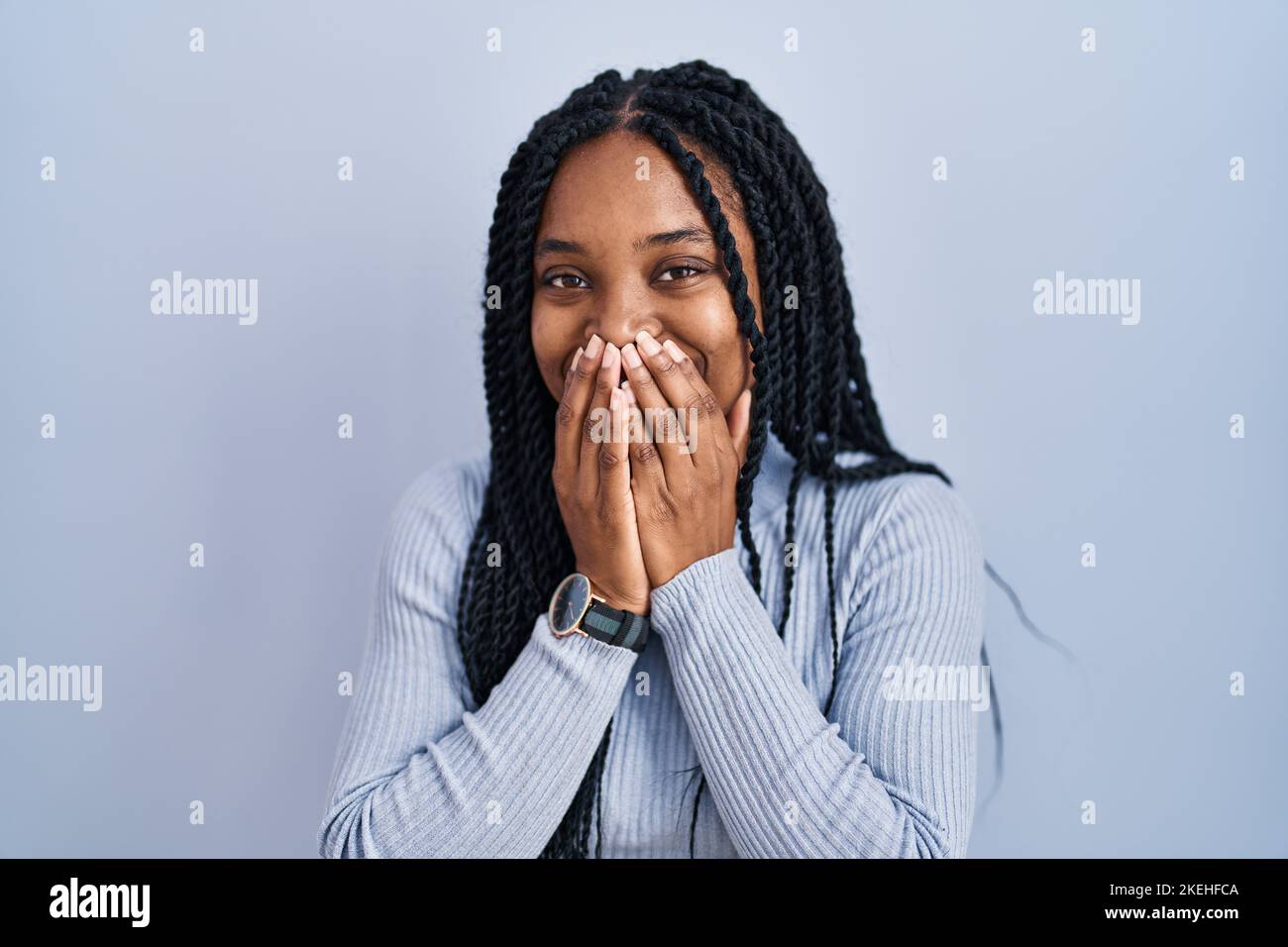 African american woman standing over blue background laughing and ...