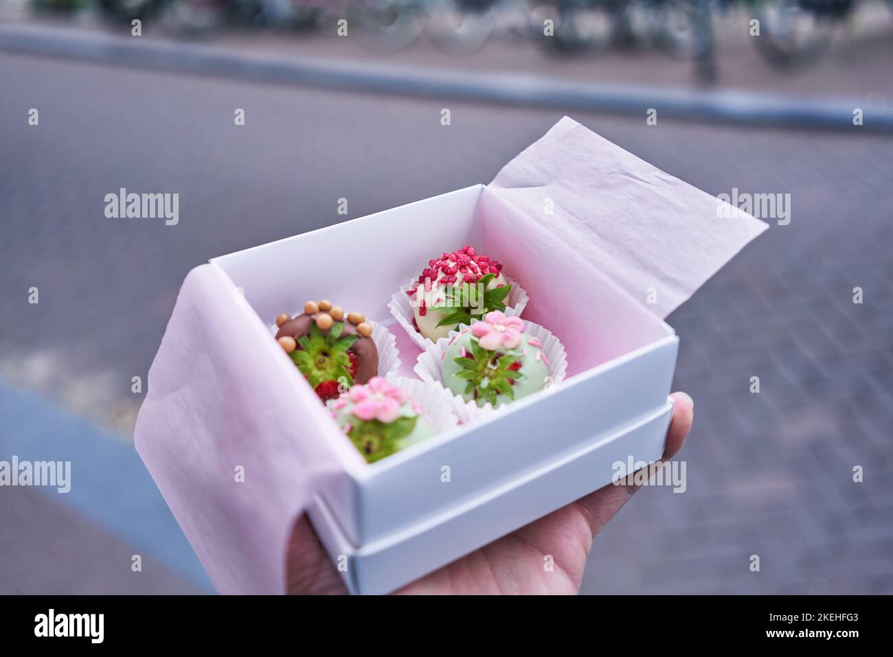 Hand of man holding box with chocolate dessert over isolated white ...