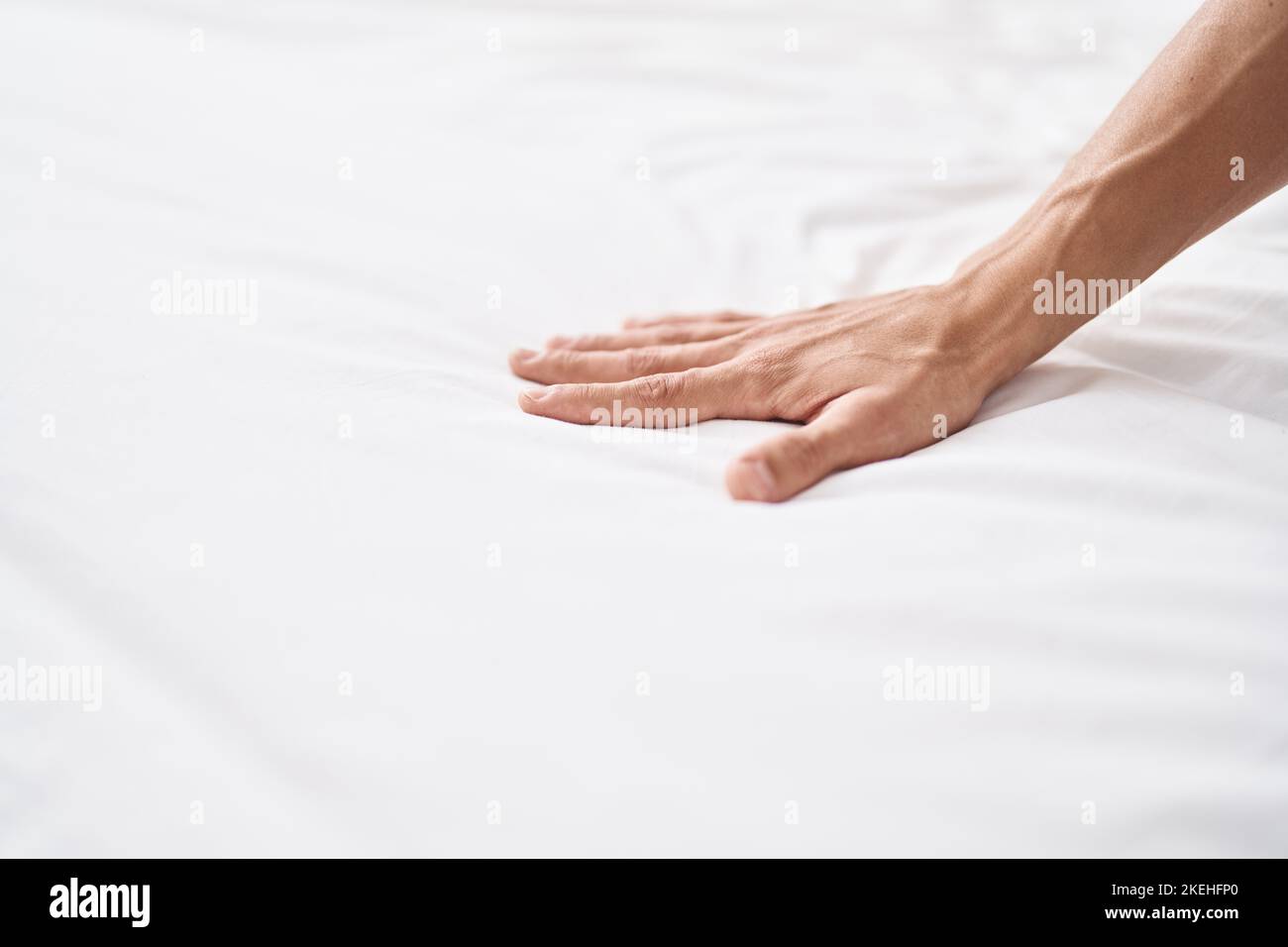 Young hispanic man stretch the sheet at bedroom Stock Photo - Alamy
