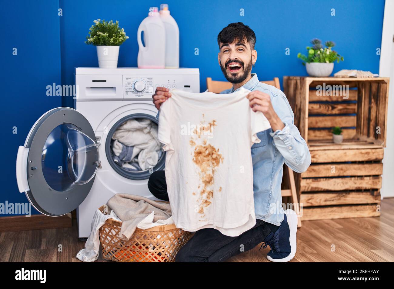 Young hispanic man with beard holding clean white t shirt and t shirt ...