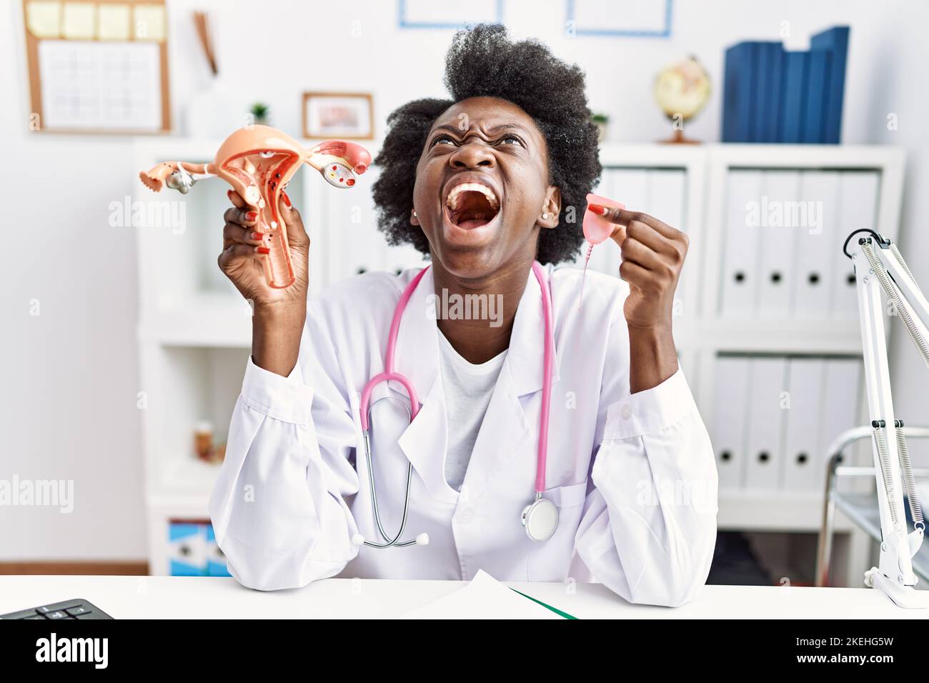 African doctor woman holding anatomical female genital organ and ...