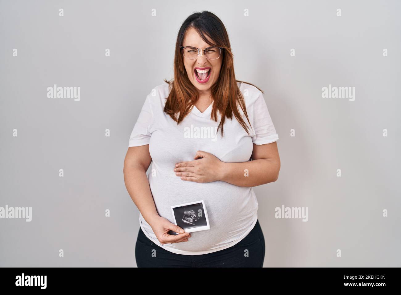 Pregnant woman holding baby ecography angry and mad screaming ...