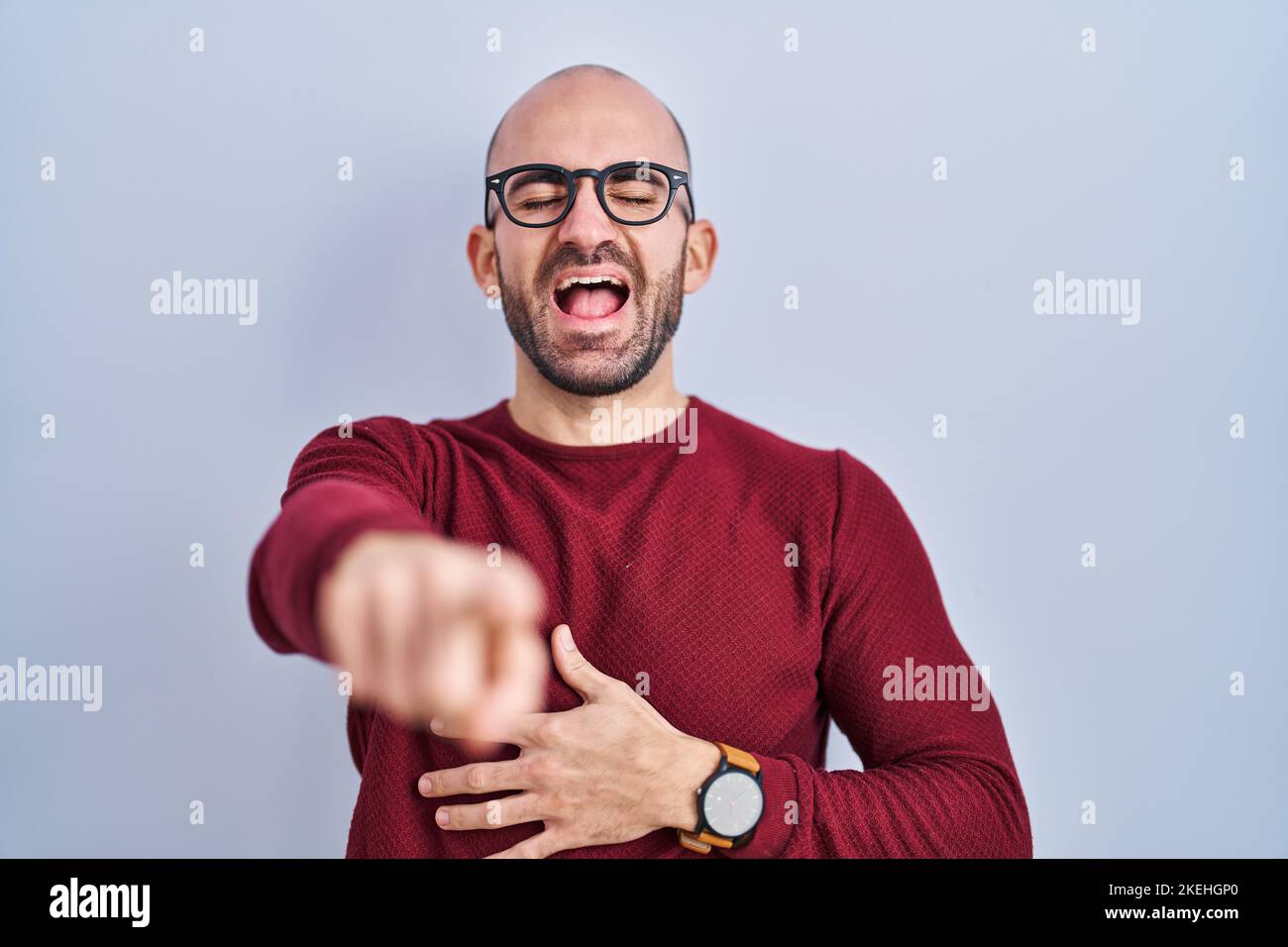 Young bald man with beard standing over white background wearing ...