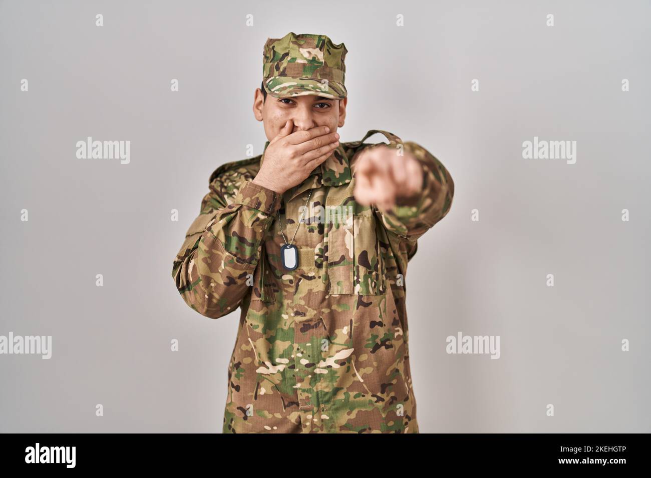 Young arab man wearing camouflage army uniform laughing at you ...