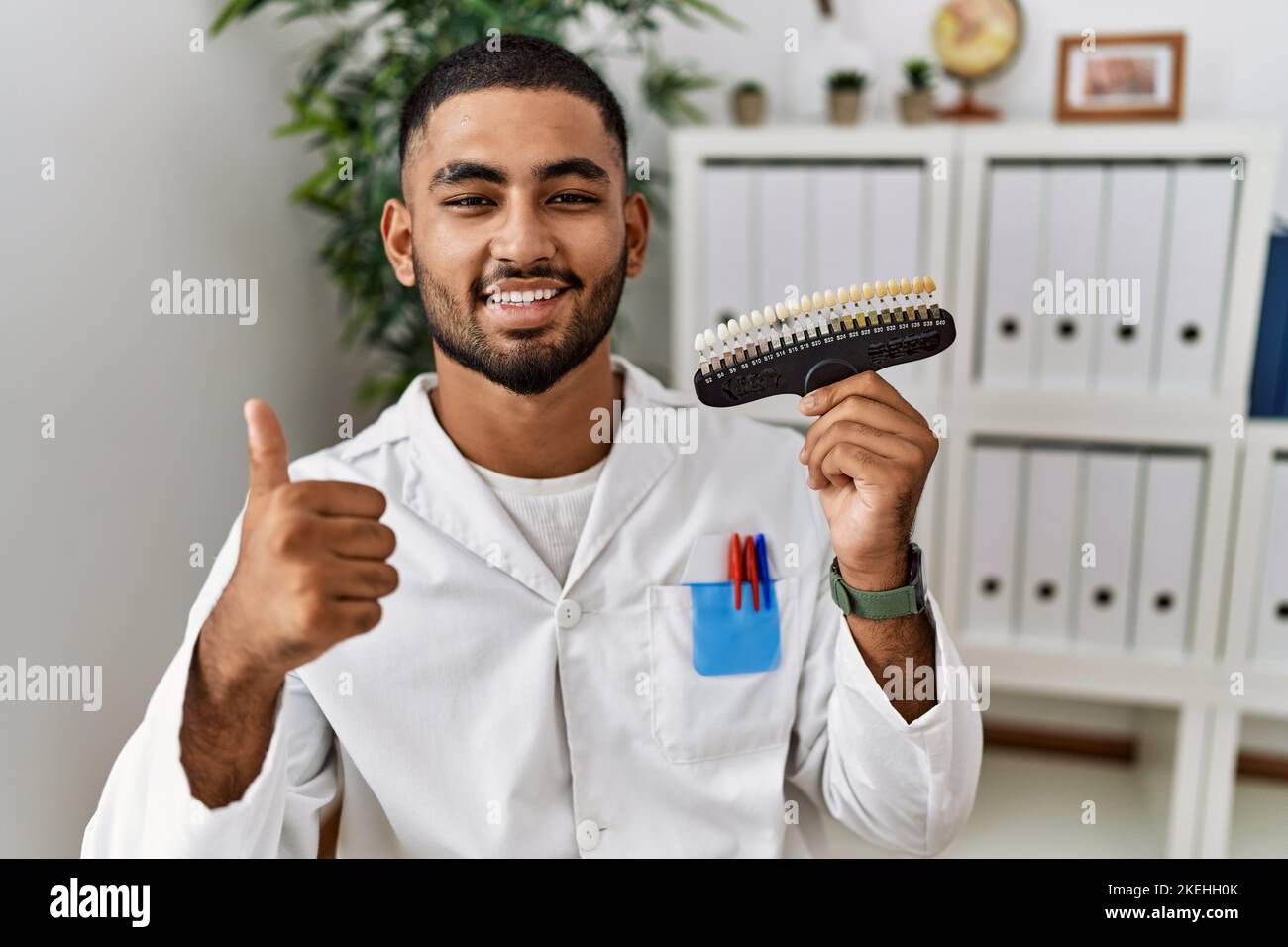 Young indian man holding teeth whitening palette smiling happy and ...