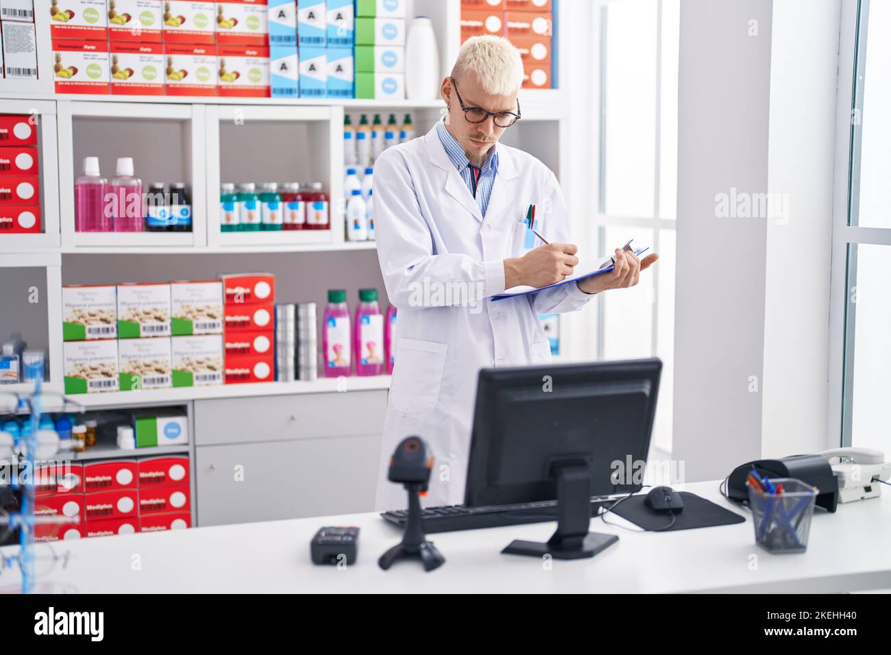 Young caucasian man pharmacist writing on document at pharmacy Stock ...