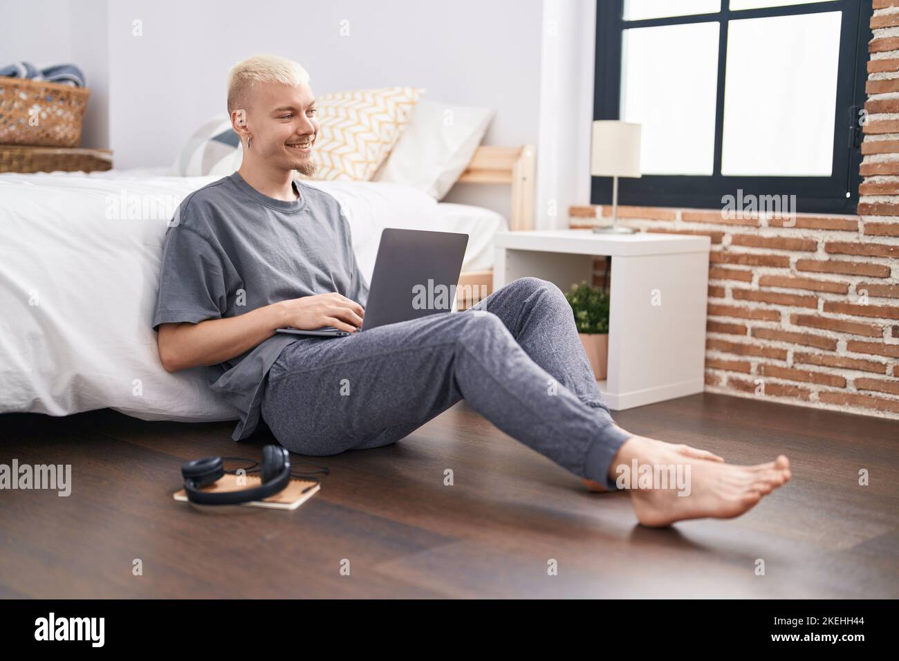 Young caucasian man using laptop sitting on floor at bedroom Stock ...