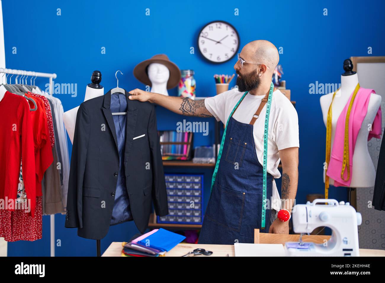 Young bald man tailor holding jacket at clothing factory Stock Photo ...