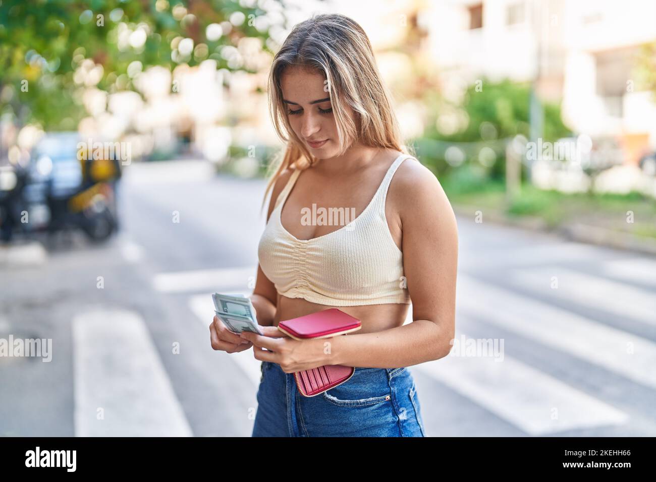 Young blonde woman smiling confident counting dollars at street Stock ...
