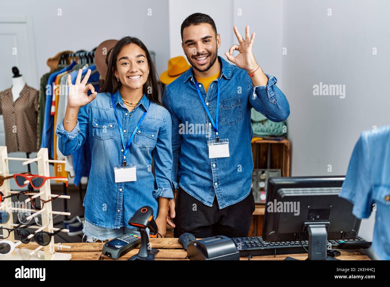 Young interracial people working at retail boutique smiling positive ...