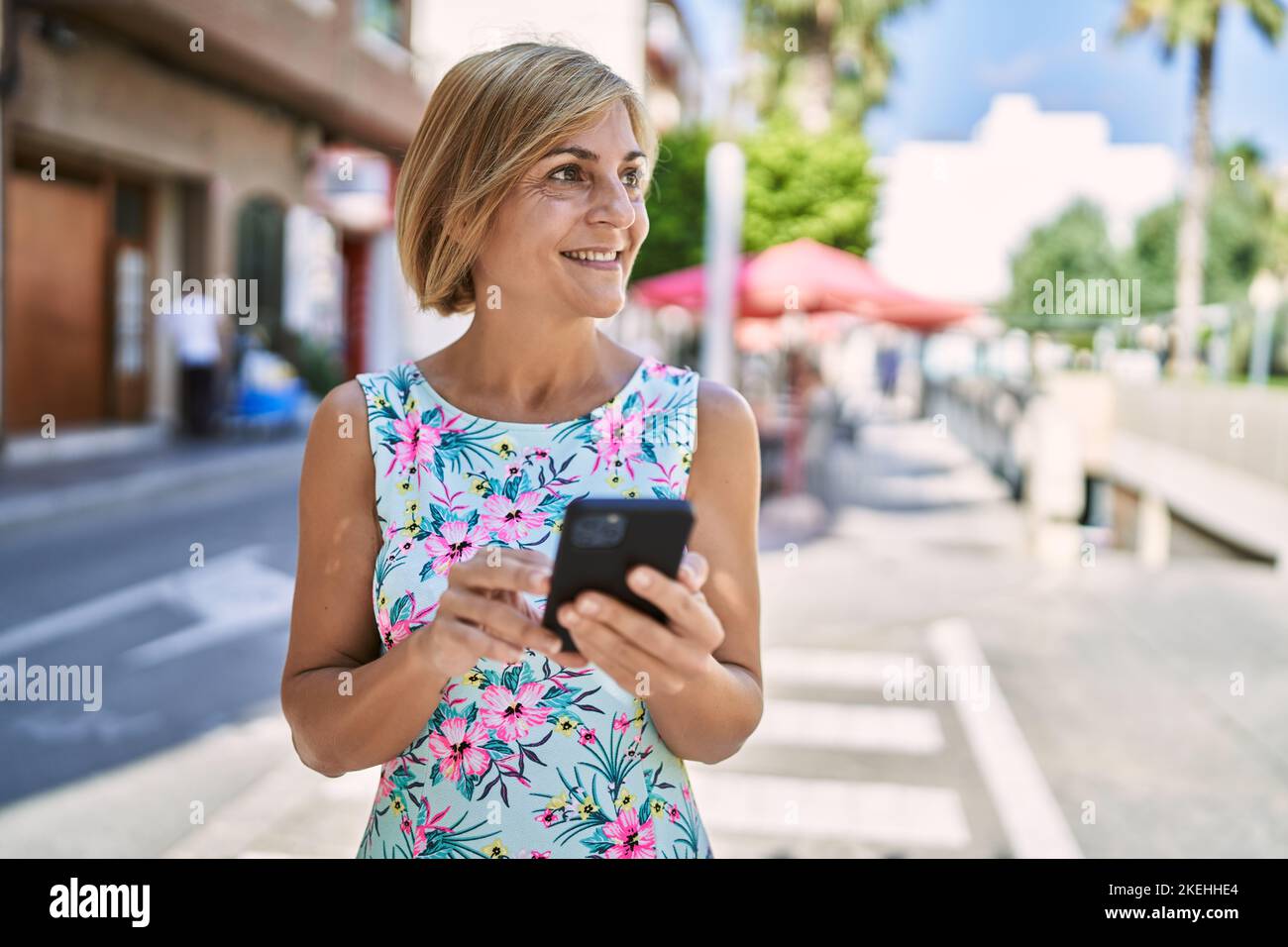 Middle age beautiful woman using smartphone at park Stock Photo - Alamy
