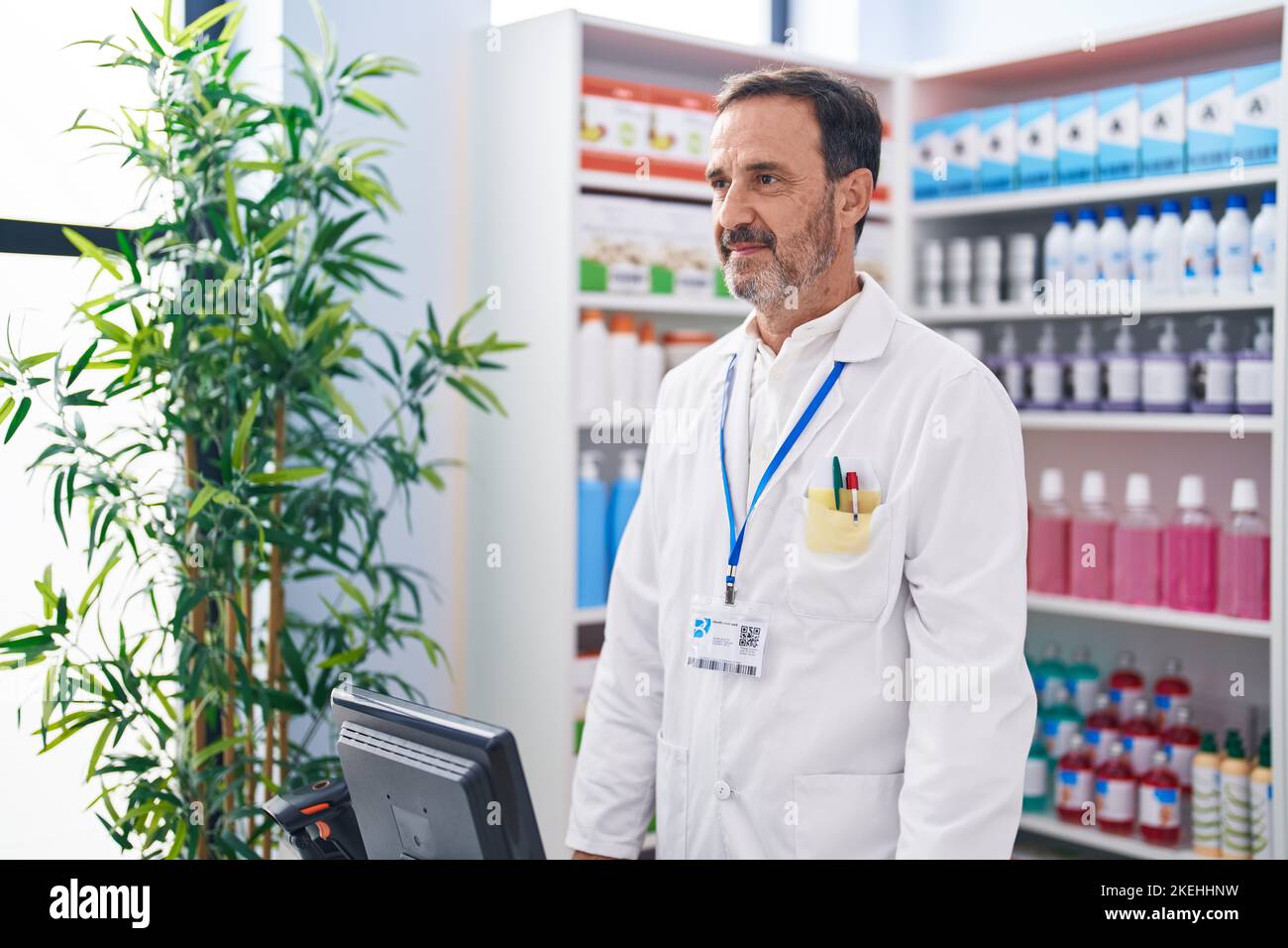Middle age man pharmacist standing with relaxed expression at pharmacy ...