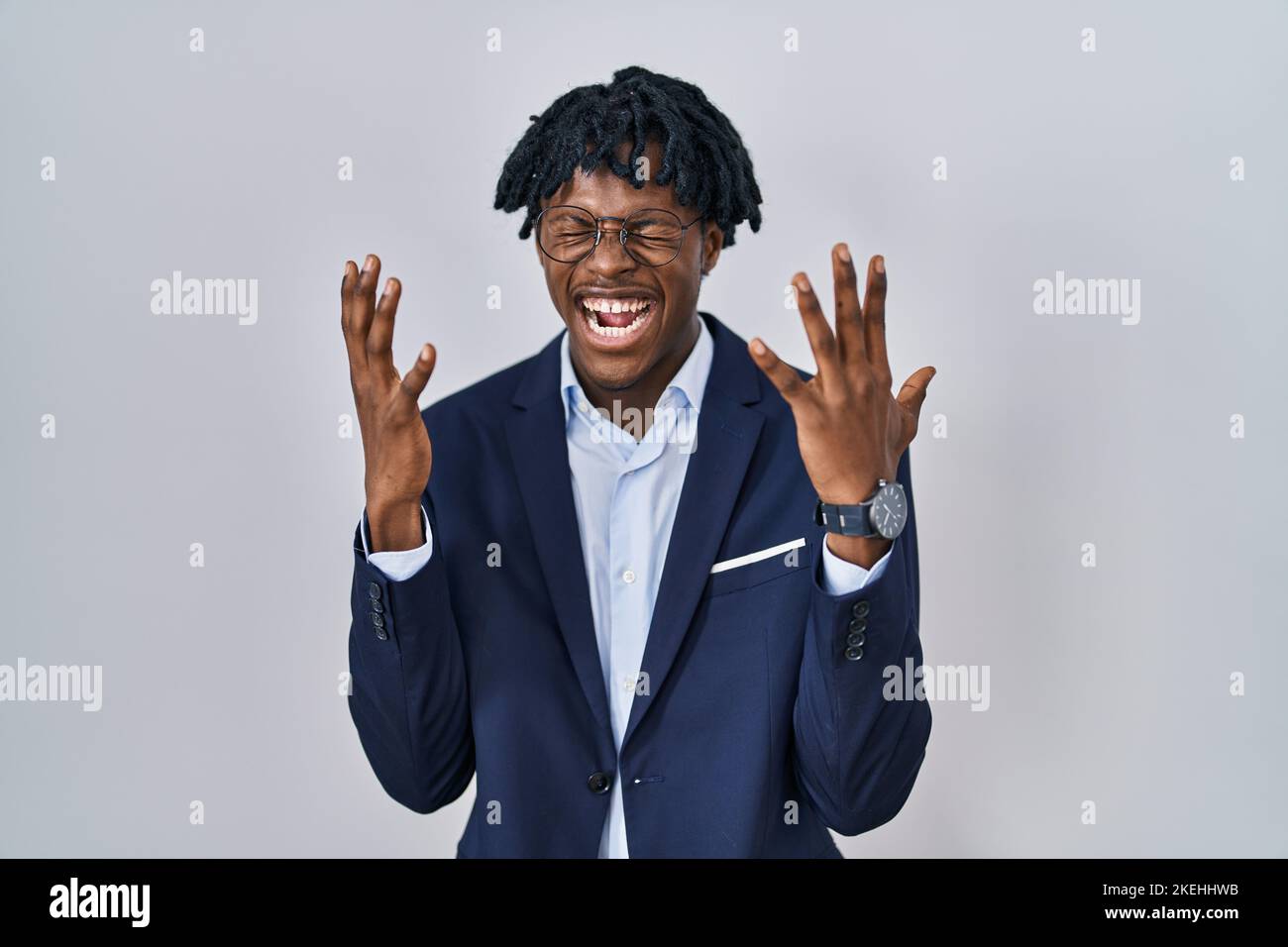 Young african man with dreadlocks wearing business jacket over white ...