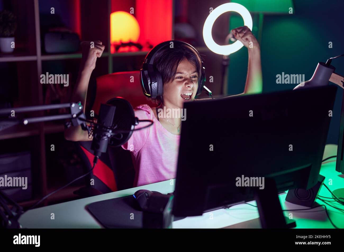 Adorable hispanic girl streamer playing video game with winner ...