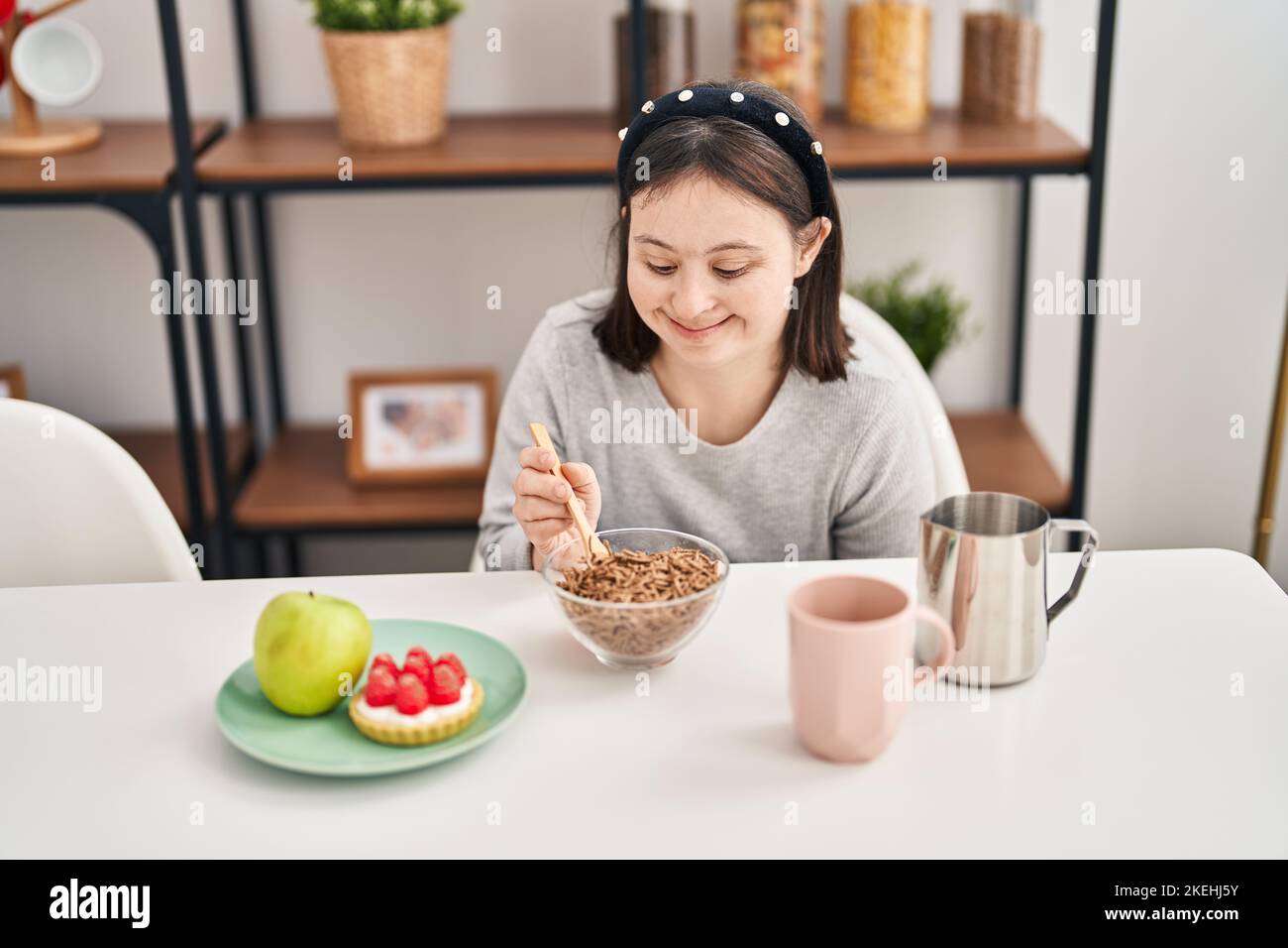 Young woman with down syndrome smiling confident having breakfast at ...