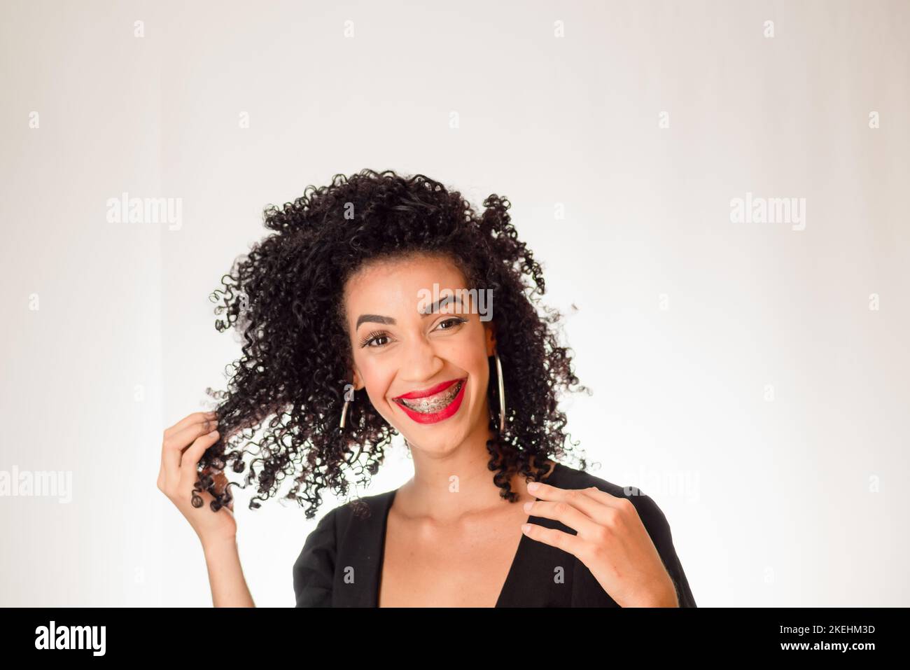 Portrait of young beautiful smiling woman with hand in hair. Looking at ...