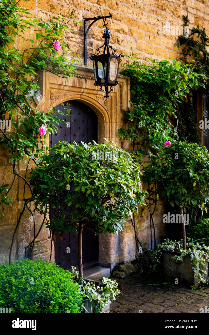 Arched stonework surrounds a studded wood door on a honey-color ...