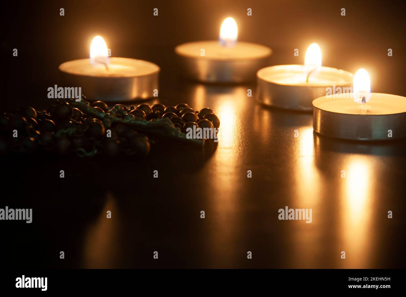 Holy Rosary on dark candlelight background with customizable space for ...