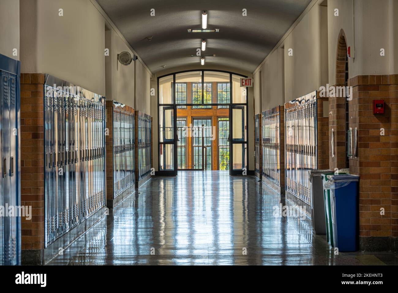 Blue metal lockers along a nondescript hallway, with windows, in a ...