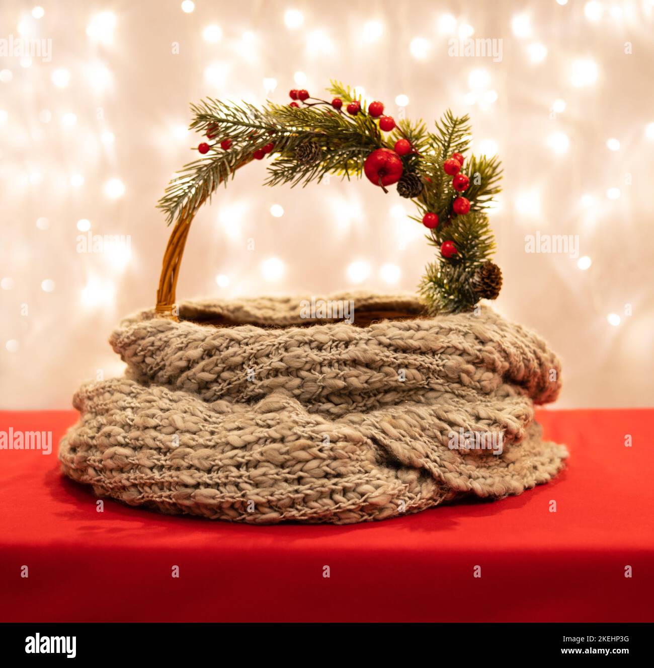Empty basket with Christmas decor and a scarf on a red background with ...