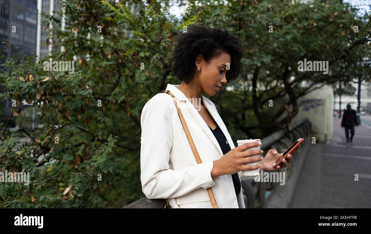black woman uses technology during an afternoon in the city Stock Photo ...