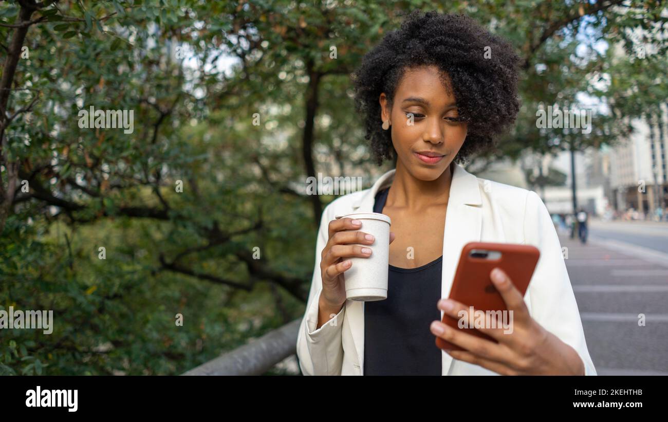 black woman uses technology during an afternoon in the city Stock Photo ...