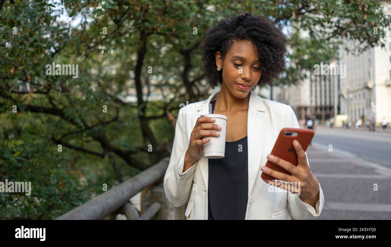 black woman uses technology during an afternoon in the city Stock Photo ...