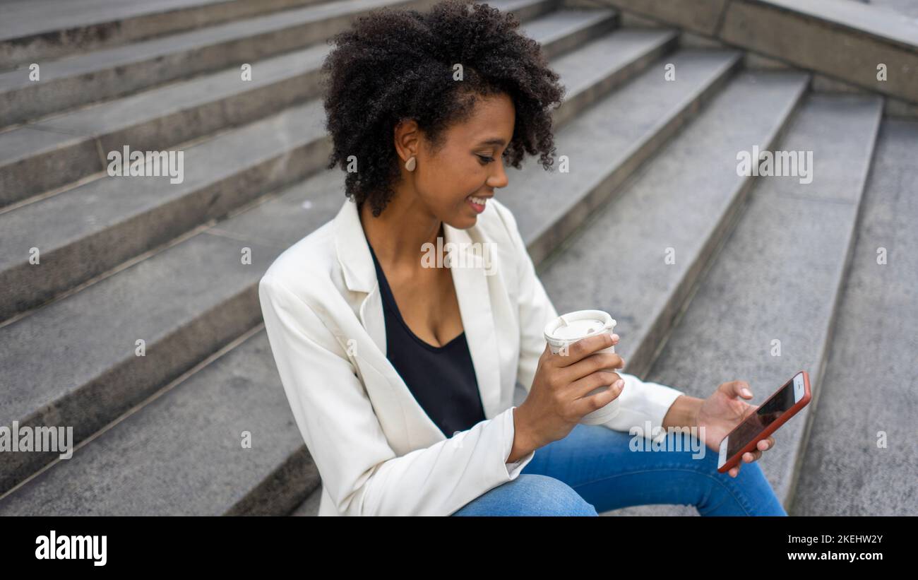 black woman uses technology during an afternoon in the city Stock Photo ...
