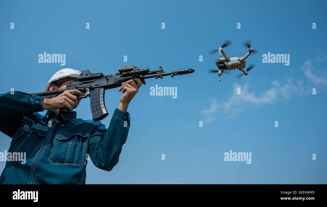 Caucasian man in a helmet shoots a flying drone with a rifle Stock ...