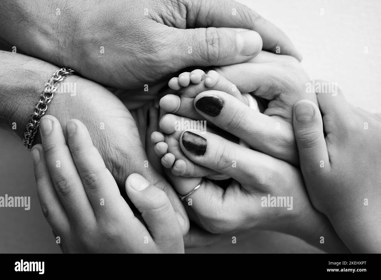 The palms of the parents, the eldest child holds the feet of the ...